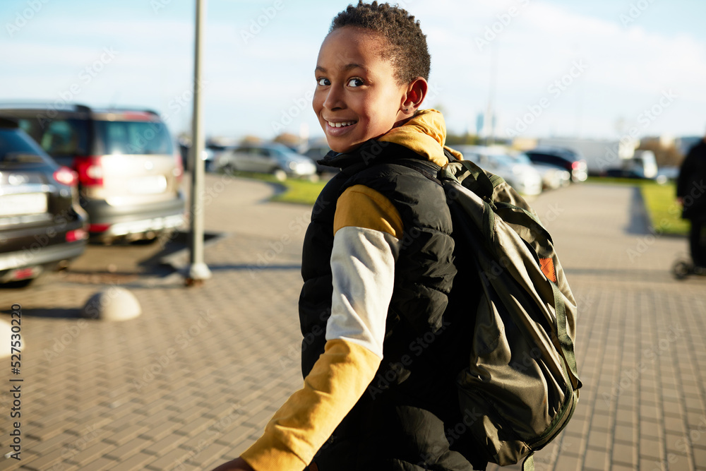 Foto de Back view of happy smiling african american schoolboy with ...