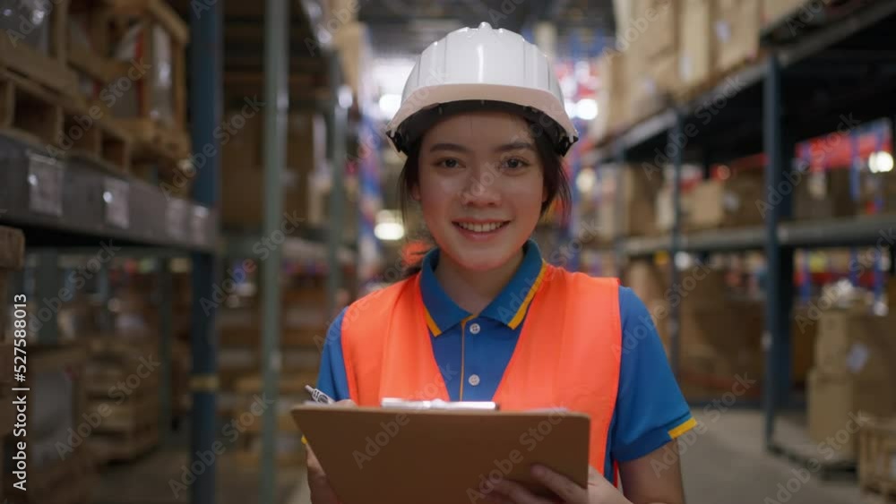 Two happy male and female warehouse staff wearing safety vest and ...