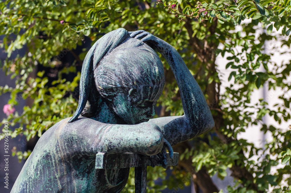 La statua bronzea di una donna dolente su una tomba del cimitero ...