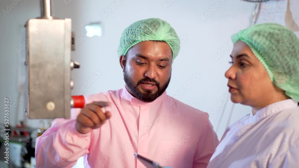 Asian quality control staff in manufacturing factory making a ...