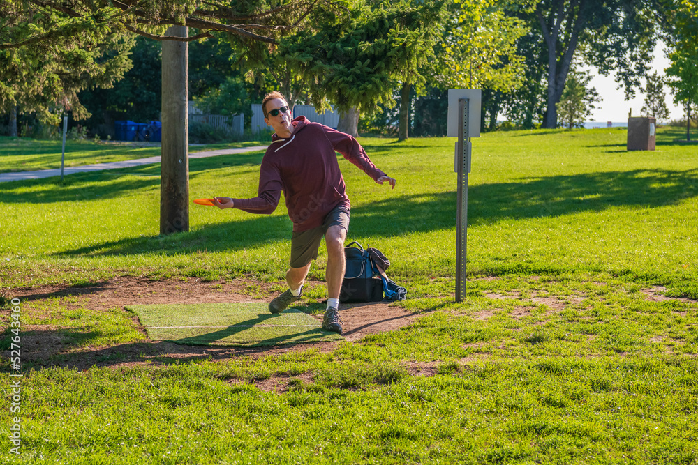 Disc golf, a flying disc sport played using rules like golf, being ...