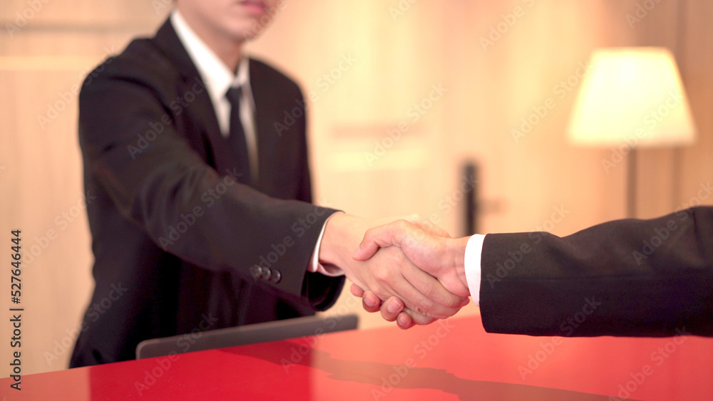 Asian young businessman making a handshake with hotel staff at the ...
