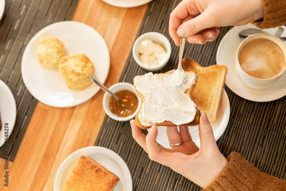 Crop woman smearing cream cheese on toast Stock Photo | Adobe Stock