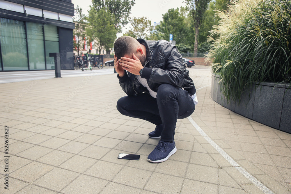 Broken glass screen of a smartphone in the hand of an upset guy on the ...
