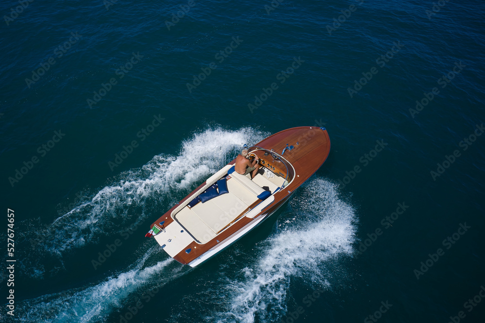 Italian wooden speedboat moving up aerial view. Wooden expensive boat ...