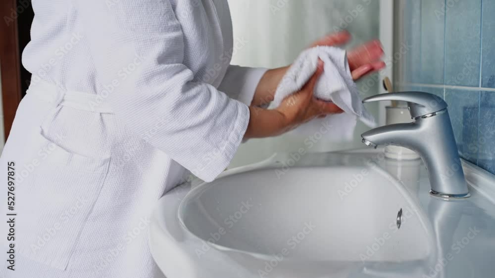 Close-up. Woman in bathrobe, washing hands with a liquid antibacterial ...