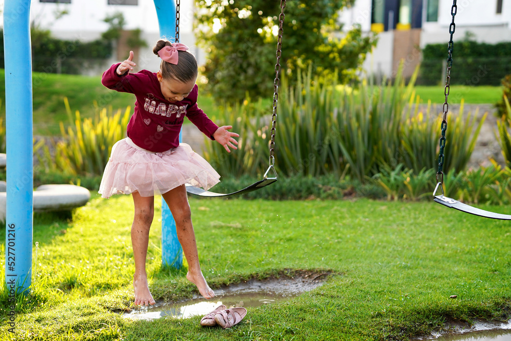 Niña feliz hermosa saltando brincando jugando en un charco de agua con ...