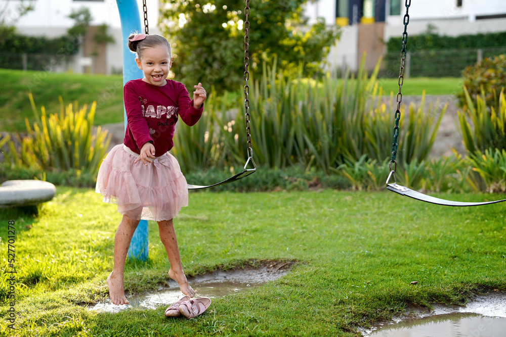 Niña feliz hermosa saltando brincando jugando en un charco de agua con ...