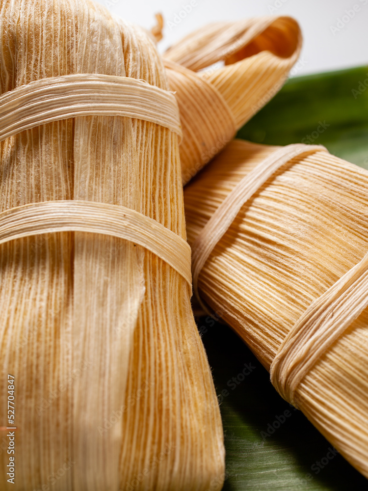 Vertical close up photo of two wrapped corn tamales, image of two ...