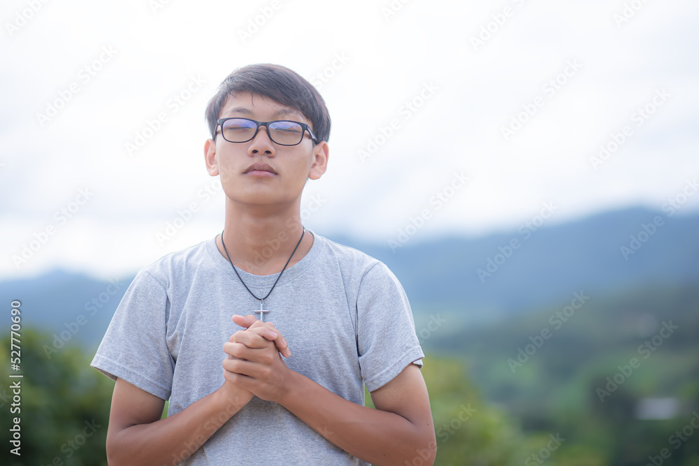 young man praying to God. male asks for help finding solace in faith ...