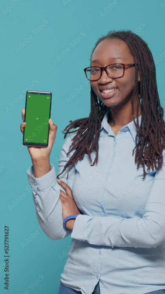 Vertical video: Female model holding smartphone with greenscreen ...