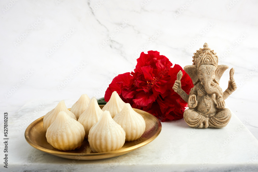 Idol of lord Ganesha with Modak Sweet Dish and flower. Ganesh chaturthi ...