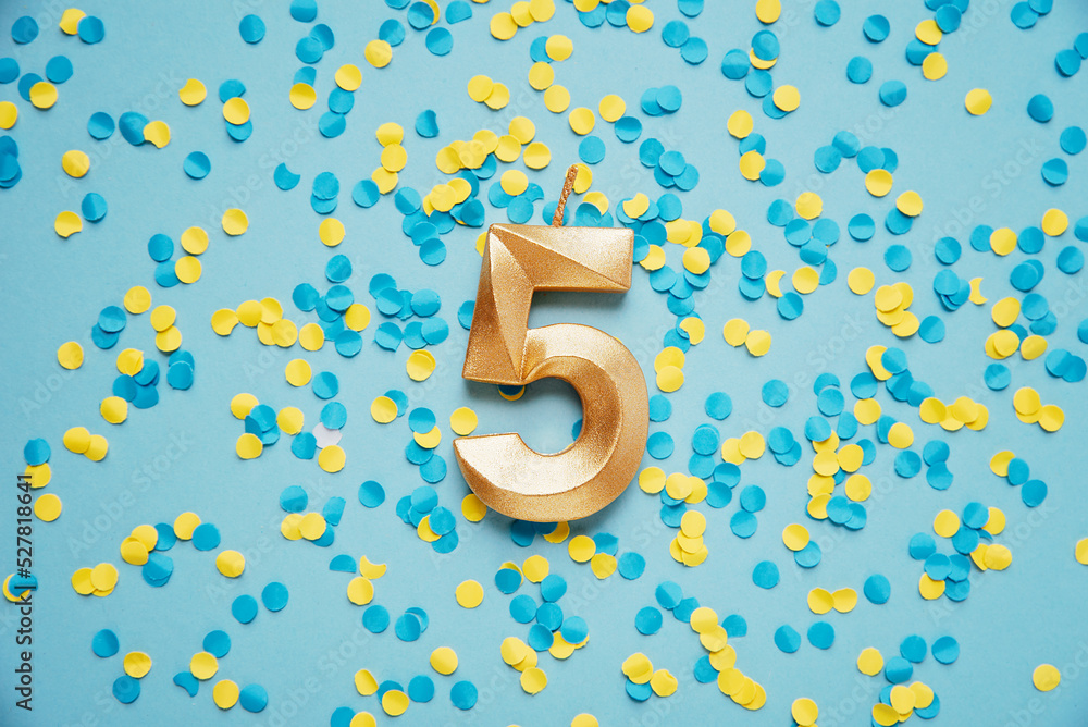 Number 5 five golden celebration birthday candle on yellow and blue ...