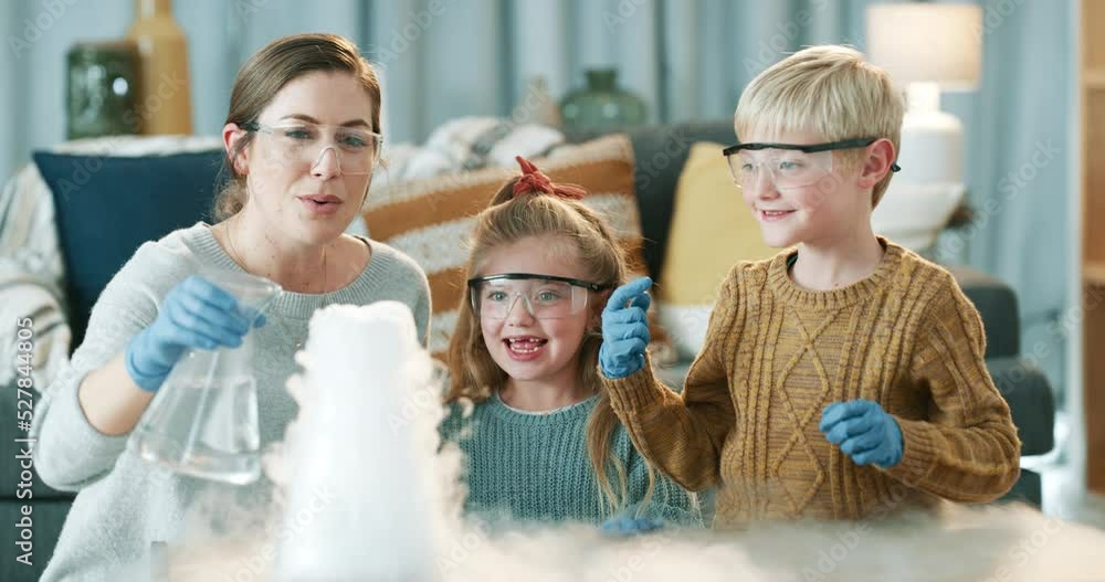 Mother doing a science project with her children in the living room ...