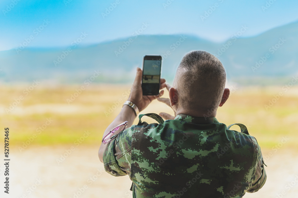 Fotografia do Stock: Back view of Asian army soldier using cell phone ...