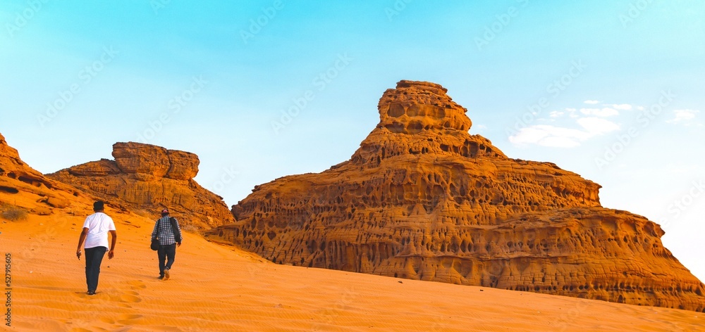 People hiking in desert surrounded by sandstone formations. An image ...