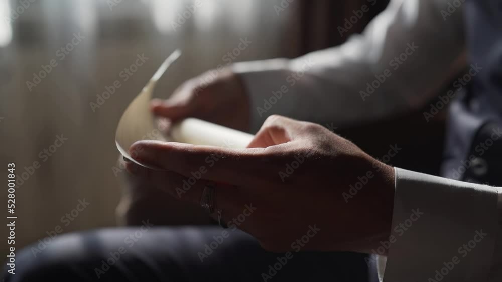 Man reads information on sheet of paper in his hand and becomes happy ...