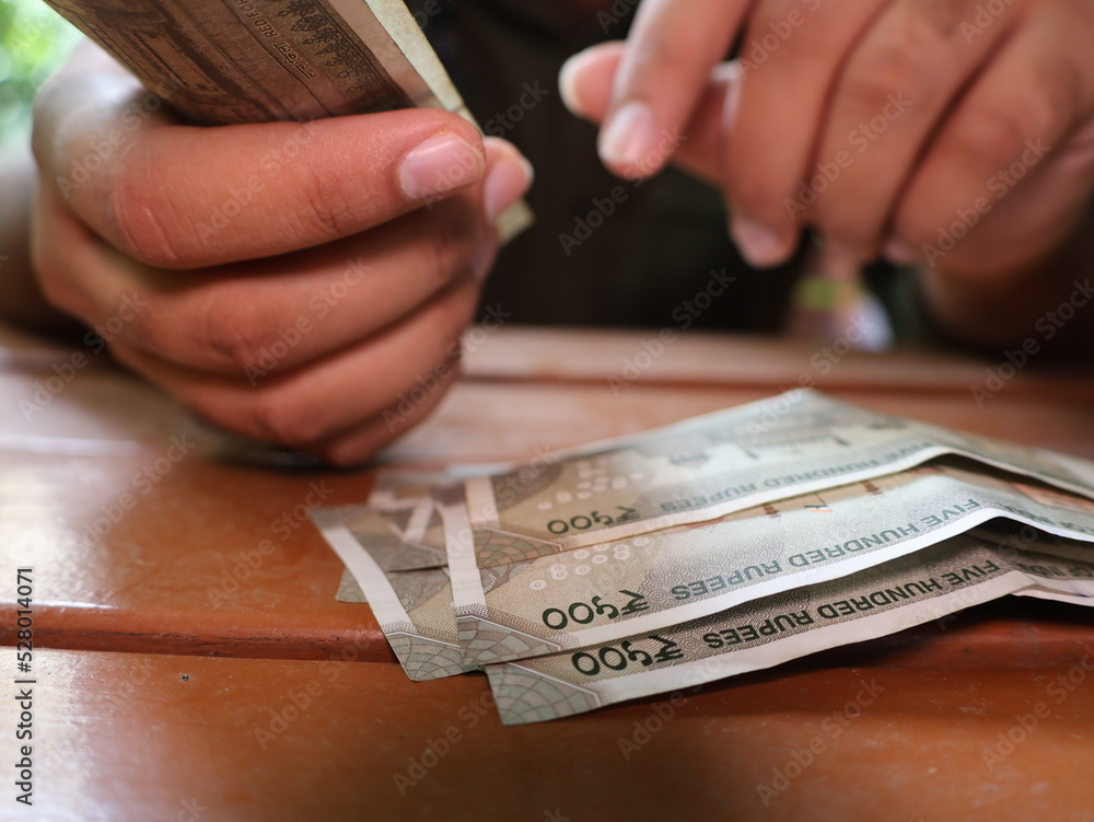 Stacking 500 denominations of Indian rupees. Close up of hand counting ...
