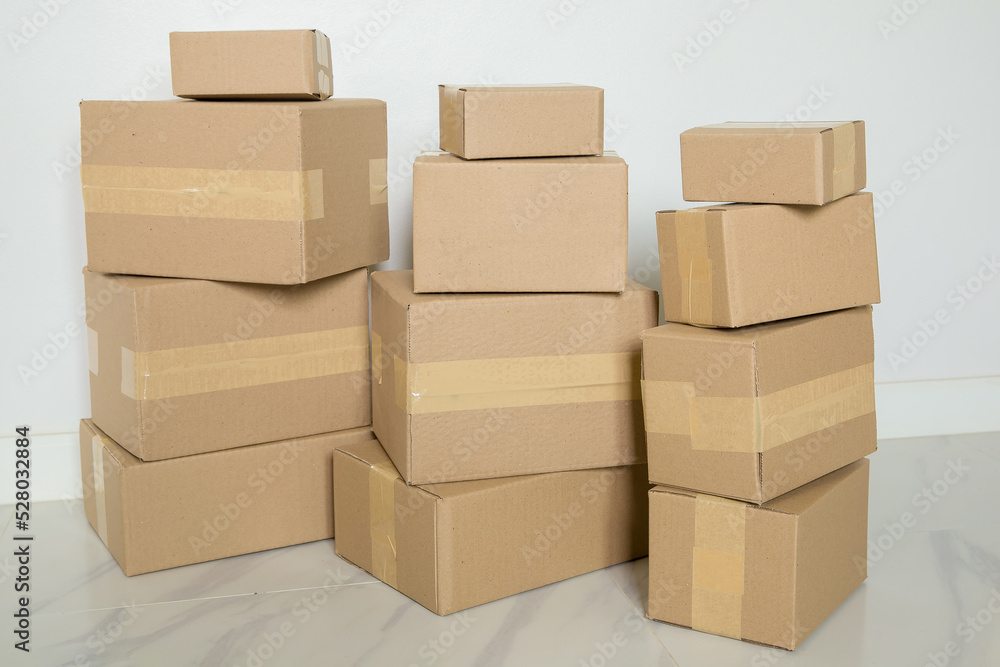 Stack of cardboard boxes for moving, Empty room with a white wall and ...
