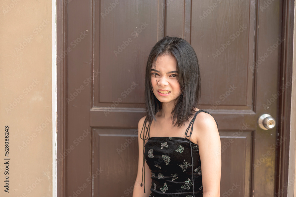 An angry teenager lookss at the camera with her eyebrows scrunched and ...