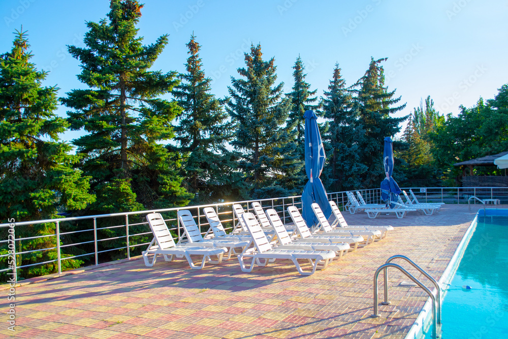 Primorsk, Ukraine. Poolside. Sunbeds near swimming pool surrounded by ...