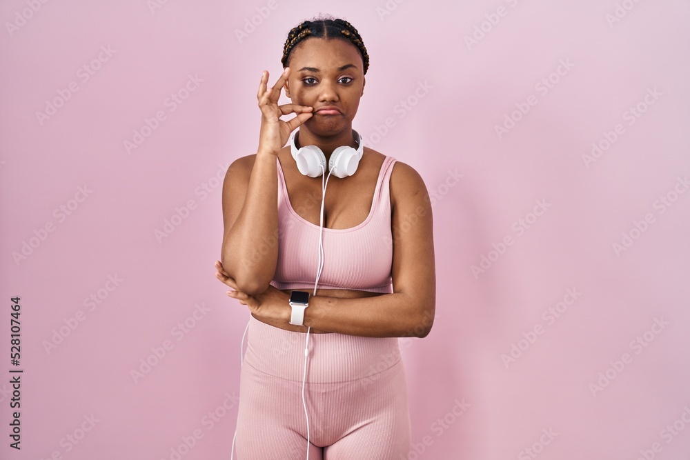 African american woman with braids wearing sportswear and headphones ...
