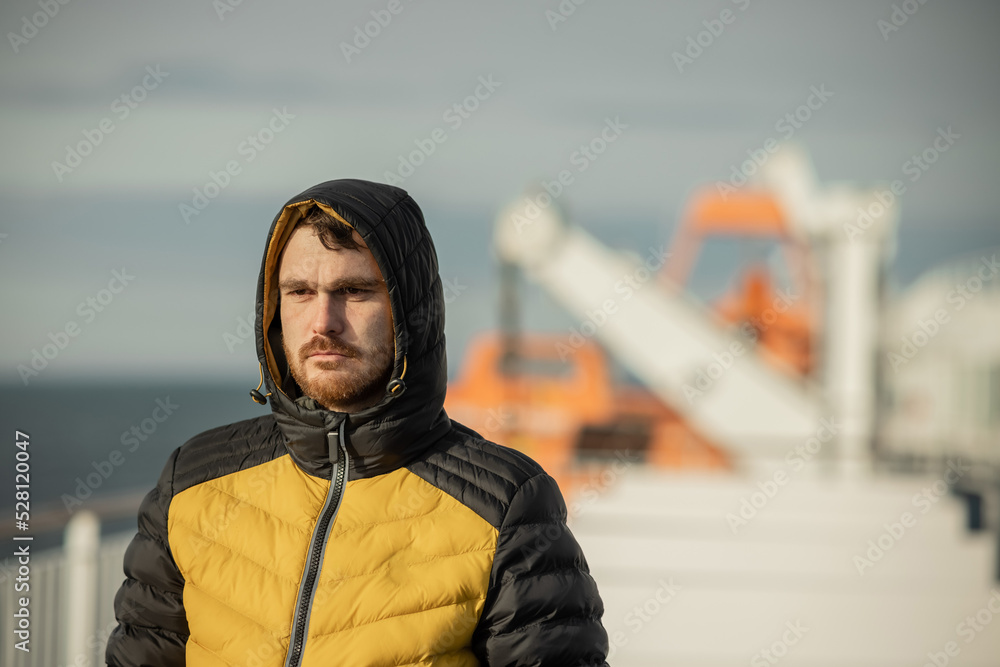 Person on a ferry in yellow and black jacket. Young fisherman male ...