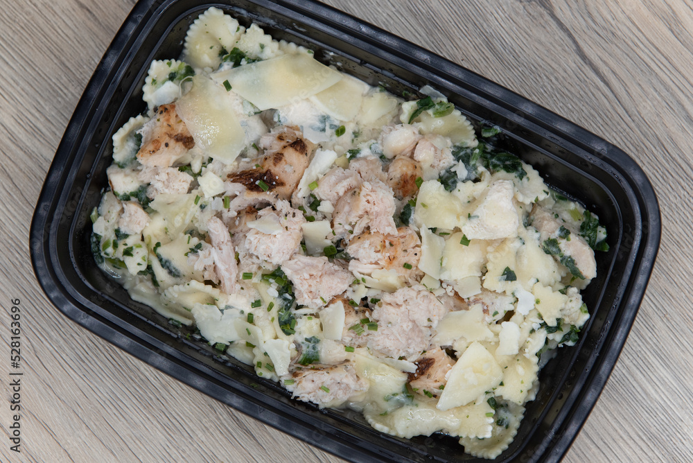 Overhead view of take out order of chicken with bow tie pasta is ...