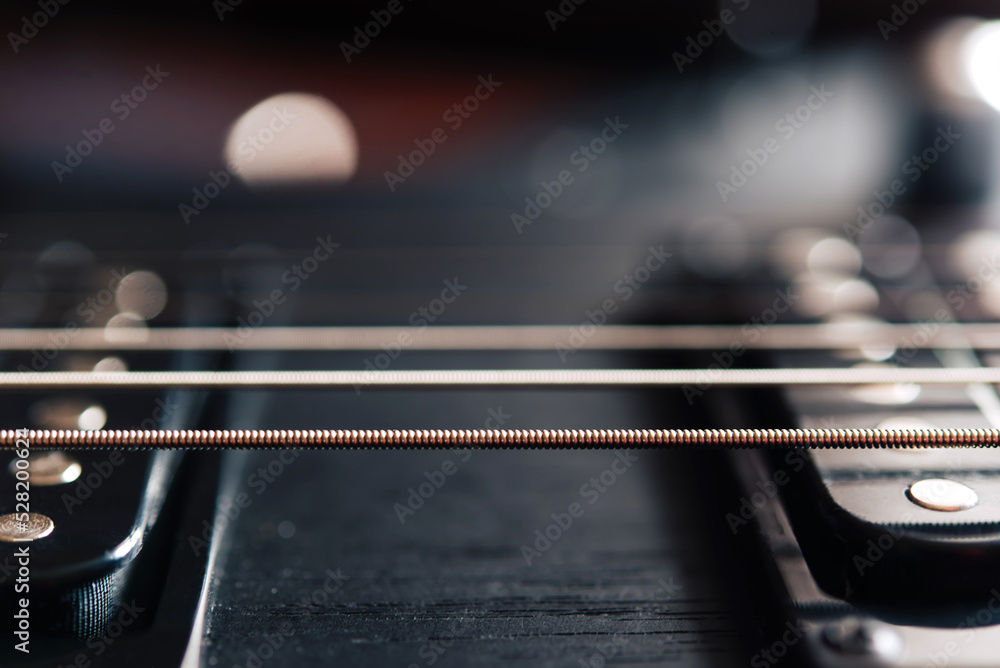 Details of the body and fretboard of an electric guitar. Stage lighting ...