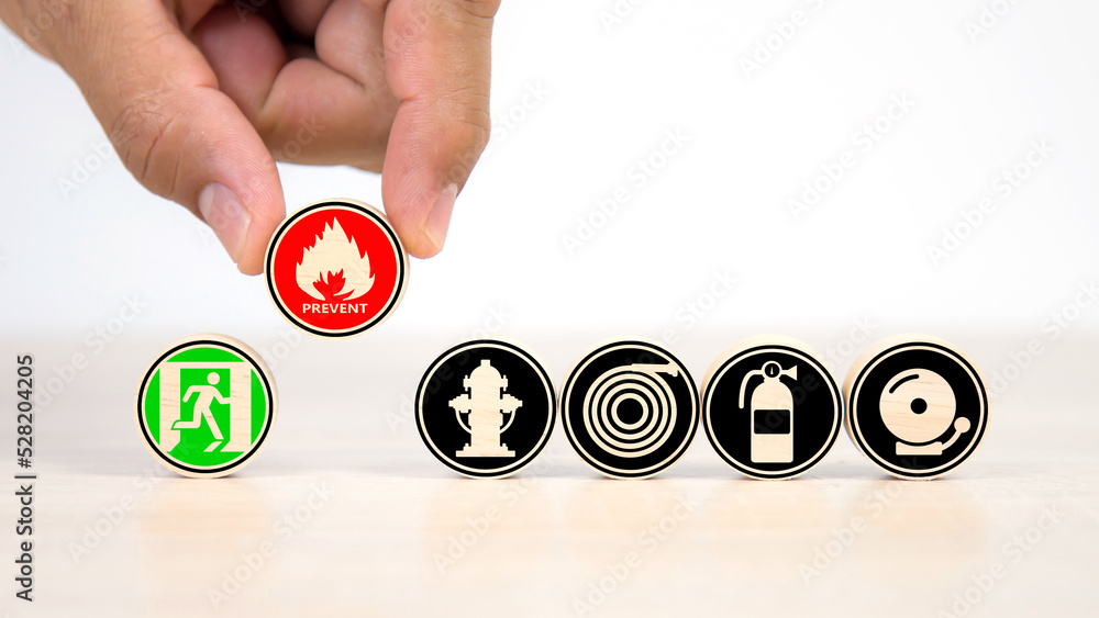 Hand choose wooden toy stack with fire prevent icon on door exit sing ...