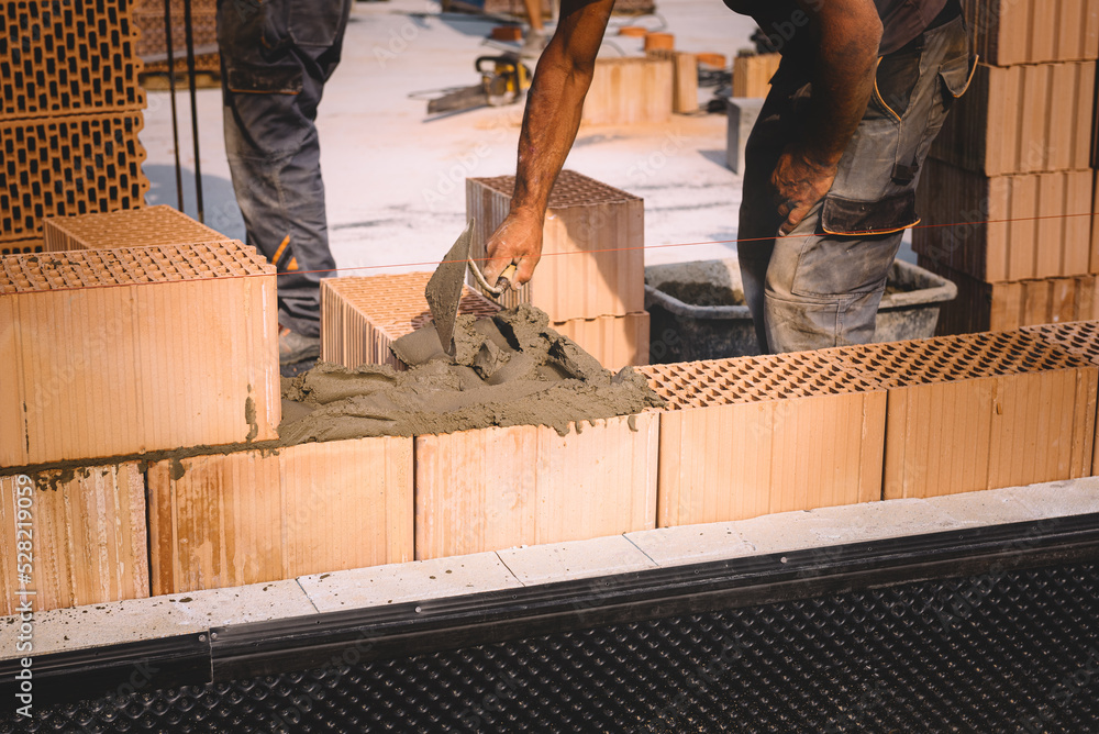 Professional construction worker laying bricks and mortar - building ...