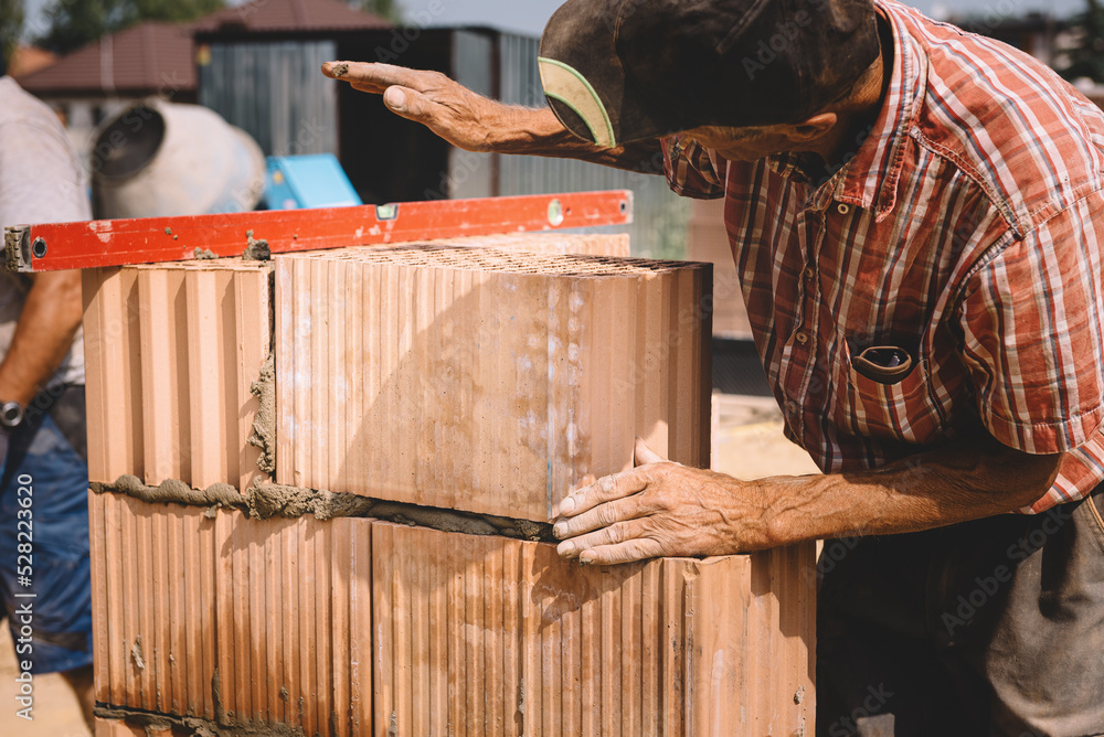 Professional construction worker laying bricks and mortar - building ...