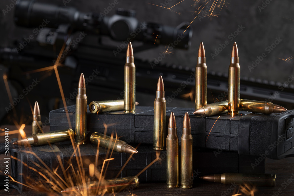 Cartridges and magazines for AR 15. Rifle in the background. Stock ...