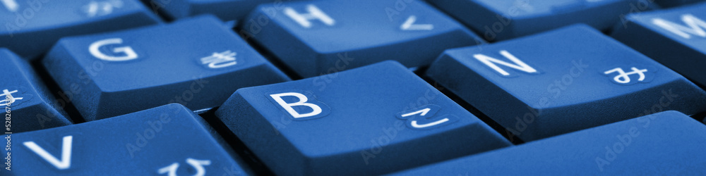 Japanese typing. Dark blue laptop keyboard. Symbols on the buttons of ...