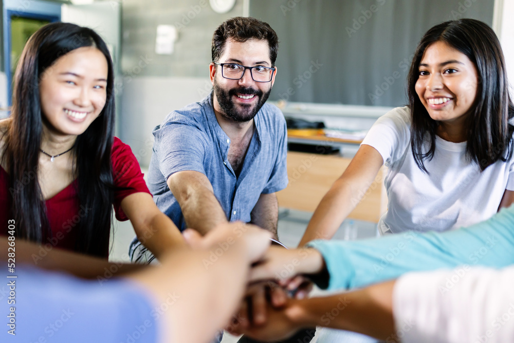 Young multiethnic group of student people stacking hands with male ...