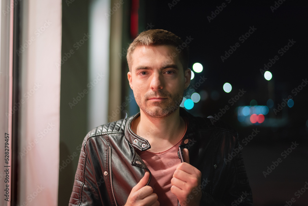 Man stands on the night city street in front of the house window. Stock ...