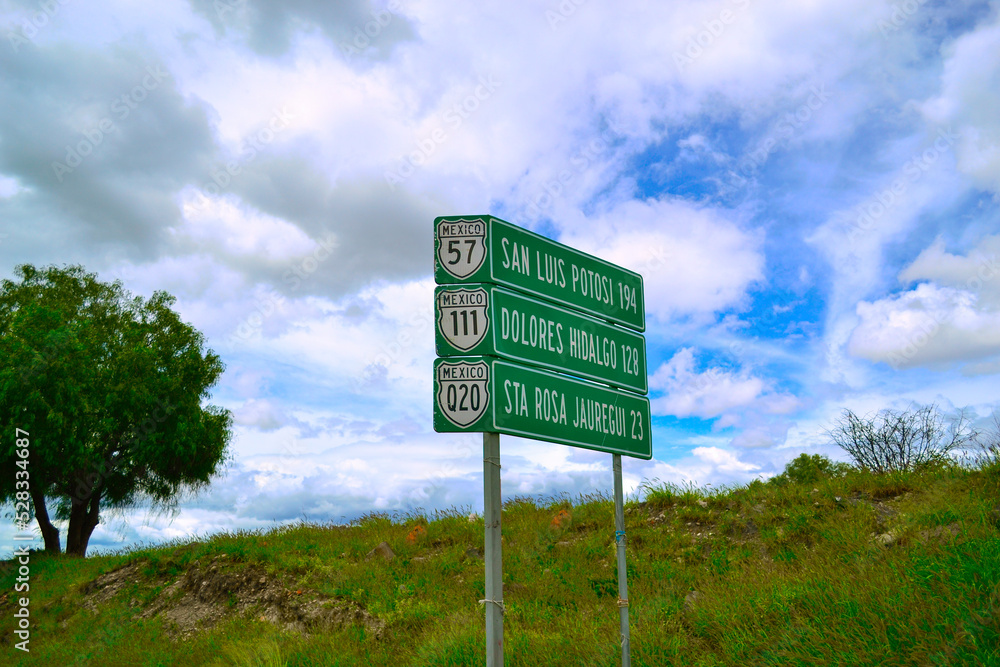 Signposts in road in green color with white letters. Signpost in the ...