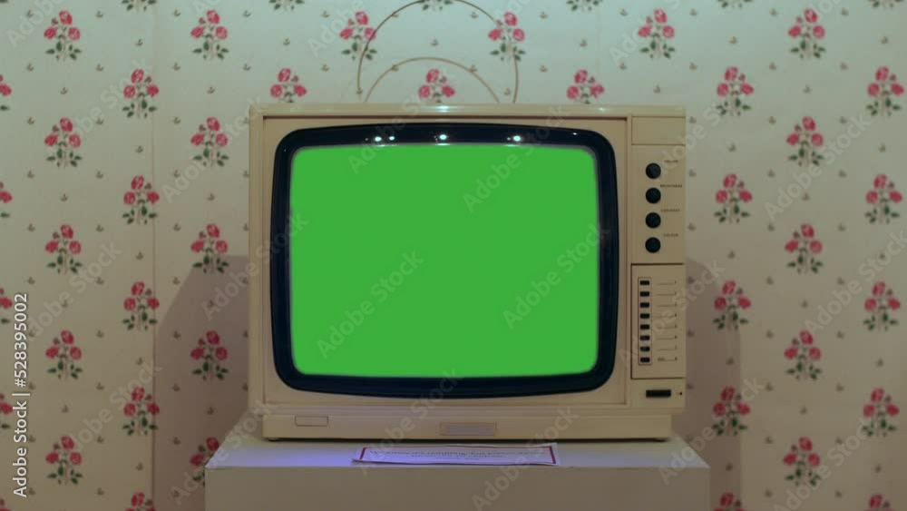 A 1980stelevision set. The TV is displaying green screen for chroma key ...