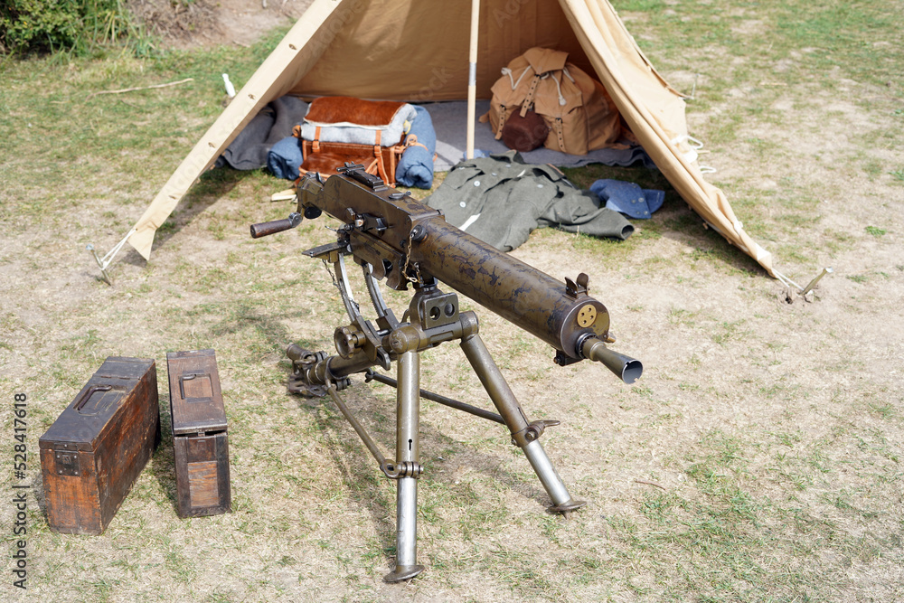 Historic firearm. We see a machine gun, a military tent and other ...