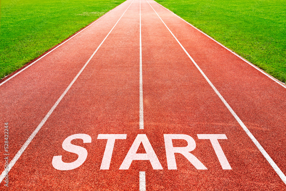 Start written on starting line on of running track of sports field ...