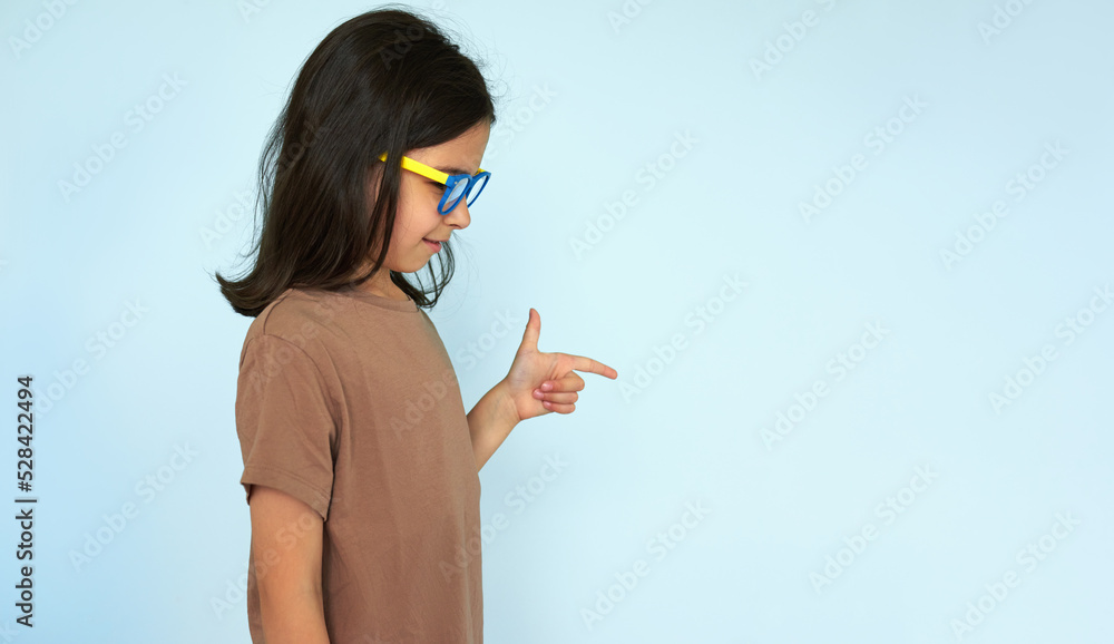 Side view horizontal image of a little girl in brown t shirt and blue ...