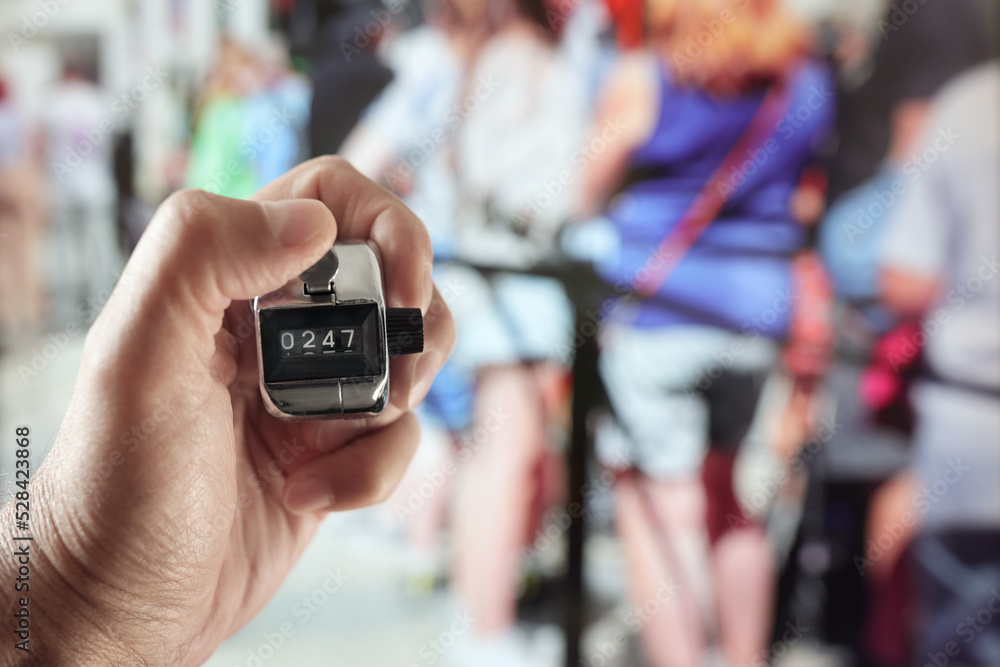 Counting people with hand held tally counter counting headcount of ...