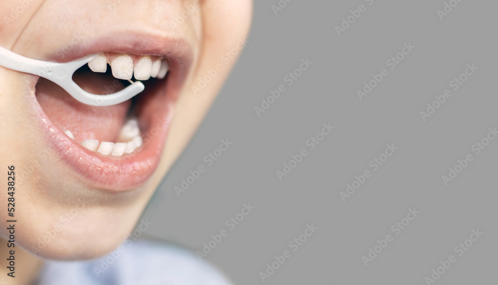 little boy is cleaning his teeth with a toothpick. plastic dental floss ...