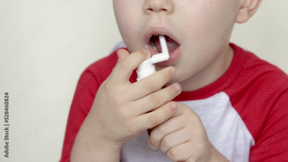kid using spray for sore throat red neck pain virus infection.close up ...