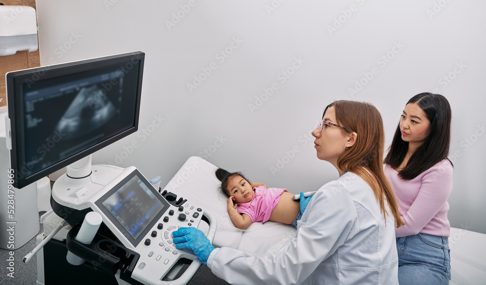 Korean little girl with support of her mother, having ultrasound ...