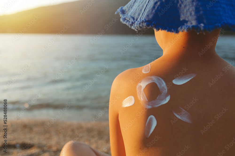 Sun protection- little boy with suncream at beach. Back view of young ...