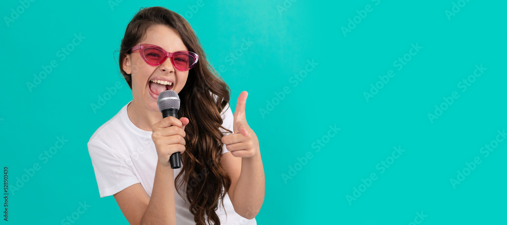 Happy girl singer point finger gun singing song to microphone blue ...