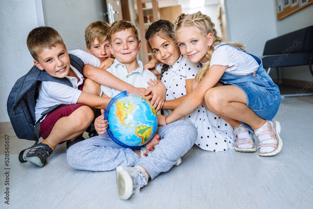 Teamwork concept. Group of five different age kids play globe ball in ...