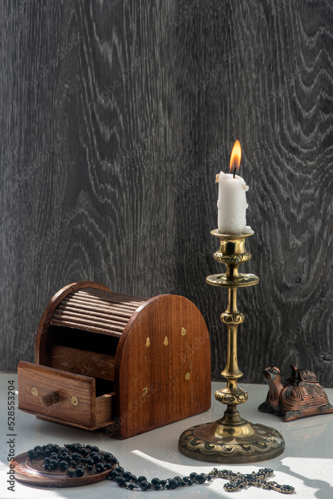 Candelabra with candle, inlaid jewelry box, women's mirror.A burning ...