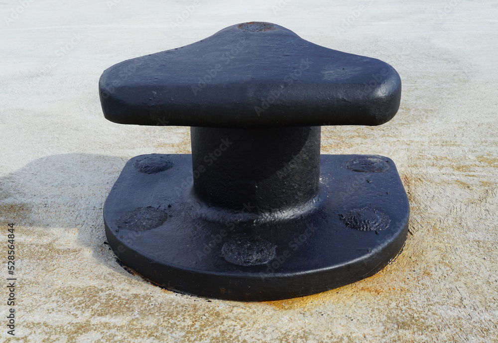 Large black metal cleat for tying large ships and ferries at the boat ...